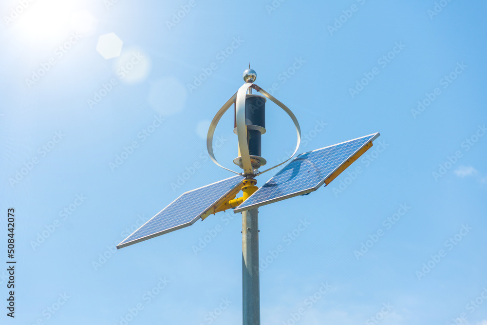 Solar panel and wind propeller mounted on a pole in the city for local ...