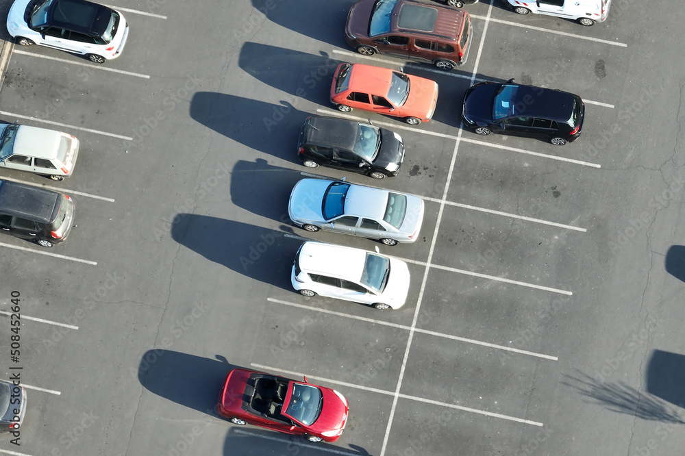 Aerial view of many colorful cars parked on parking lot with lines and ...