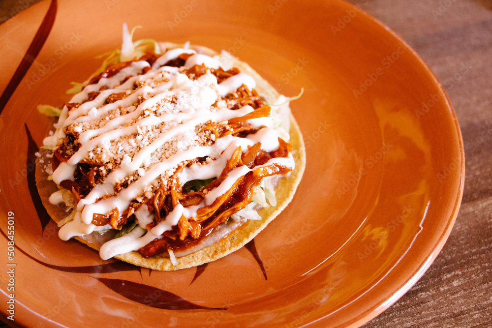 Tostada de tinga de pollo con queso y crema Stock Photo | Adobe Stock