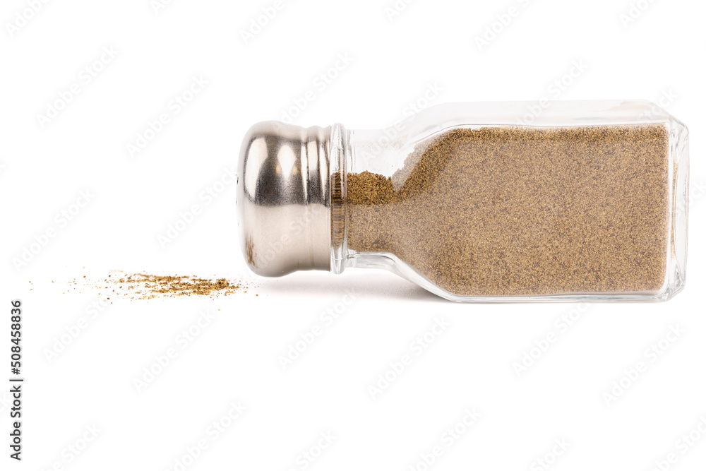 glass pepper pot with powdered black pepper inside dropped on its side ...
