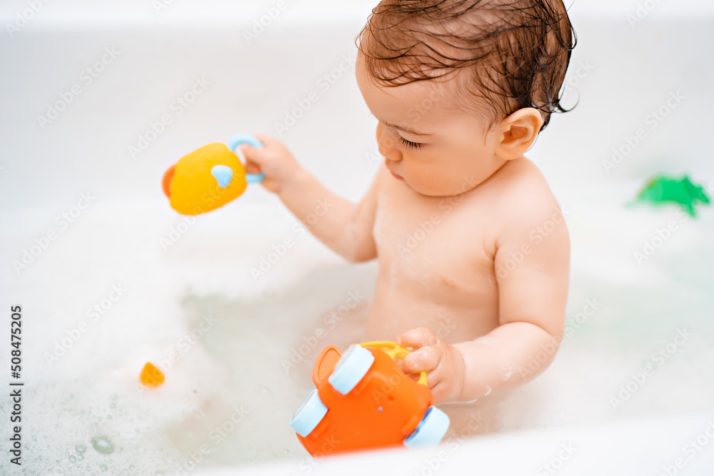 Little cute baby take a bath and playing with foam bubbles and toy ...