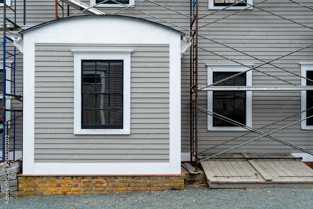 Vintage identical double hung windows on a beige color exterior wall of ...