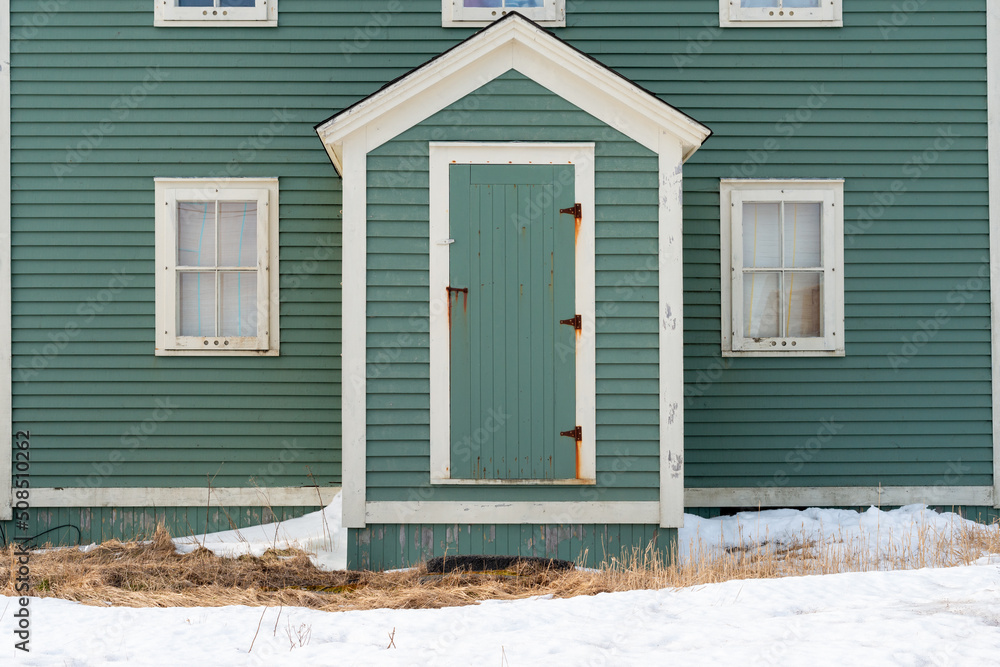 The exterior facade of a vintage wooden building. There's a green ...