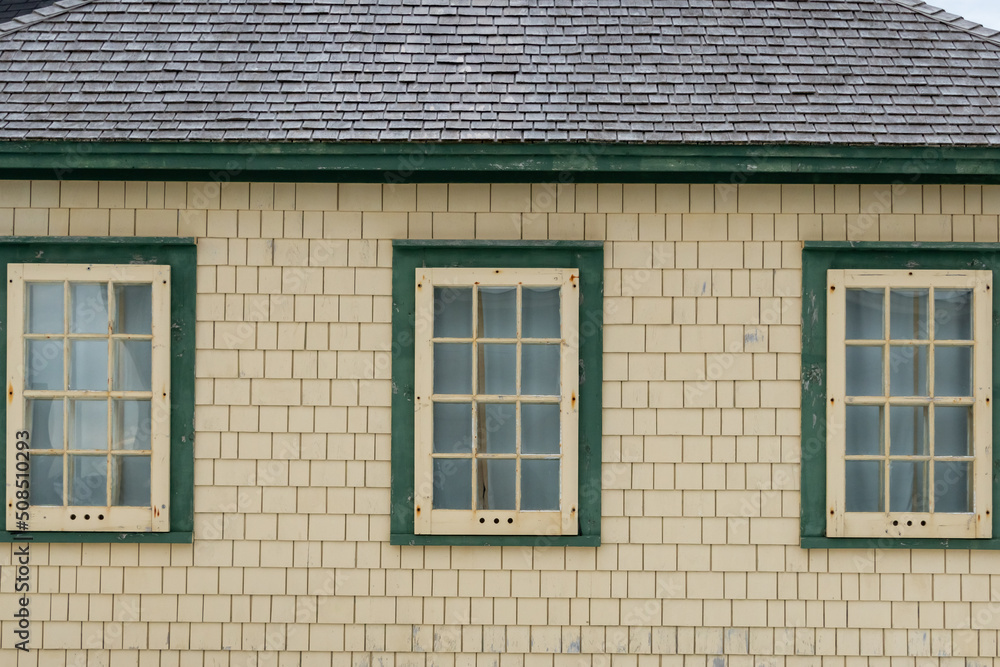 A vintage yellow cedar shake clapboard house with a grey shingled ...