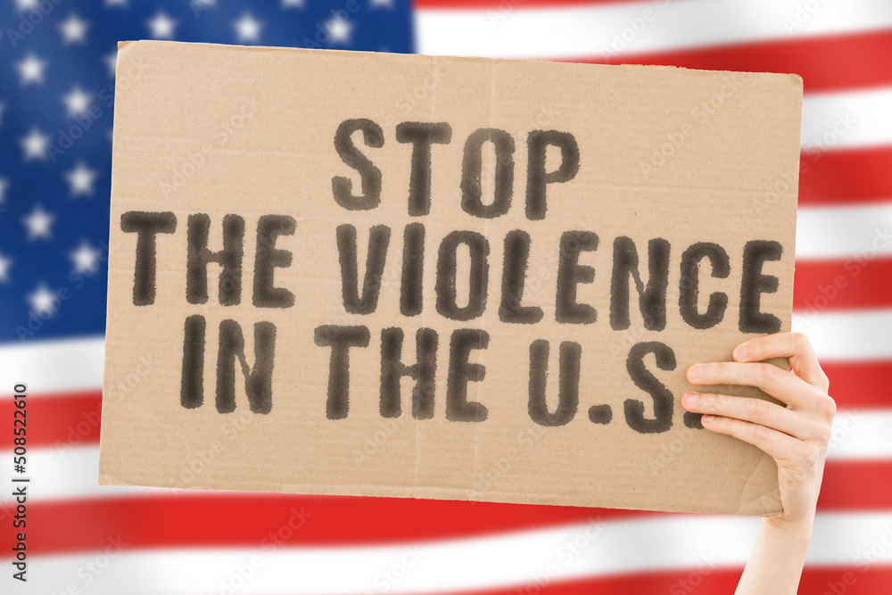 The phrase " Stop the violence in the U.S. " is on a banner in men's ...