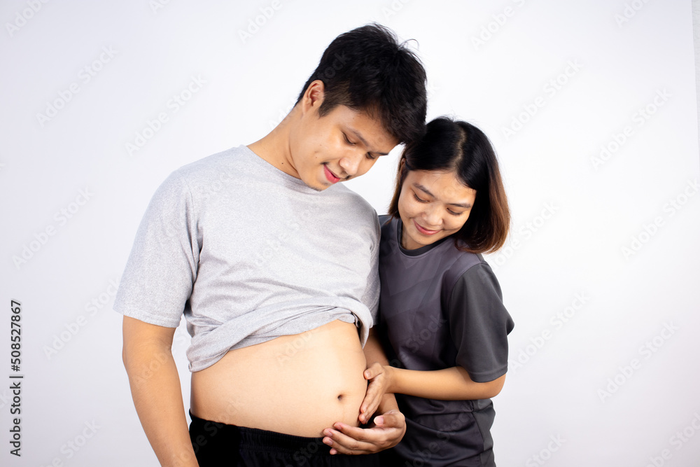 A happy couple, wishing for a baby, are rehearsing their pregnancy by ...