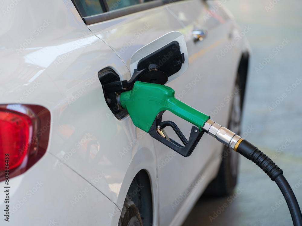 Gas pump nozzle in the fuel tank of a white car, refuel Stock Photo ...