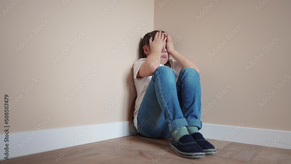 sad girl sitting in the corner crying a covered her face with her ...