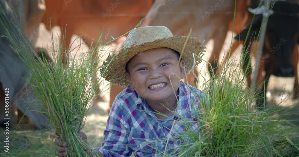 Slow motion scene of a happy smiling Asian farmer boy waring hat and ...