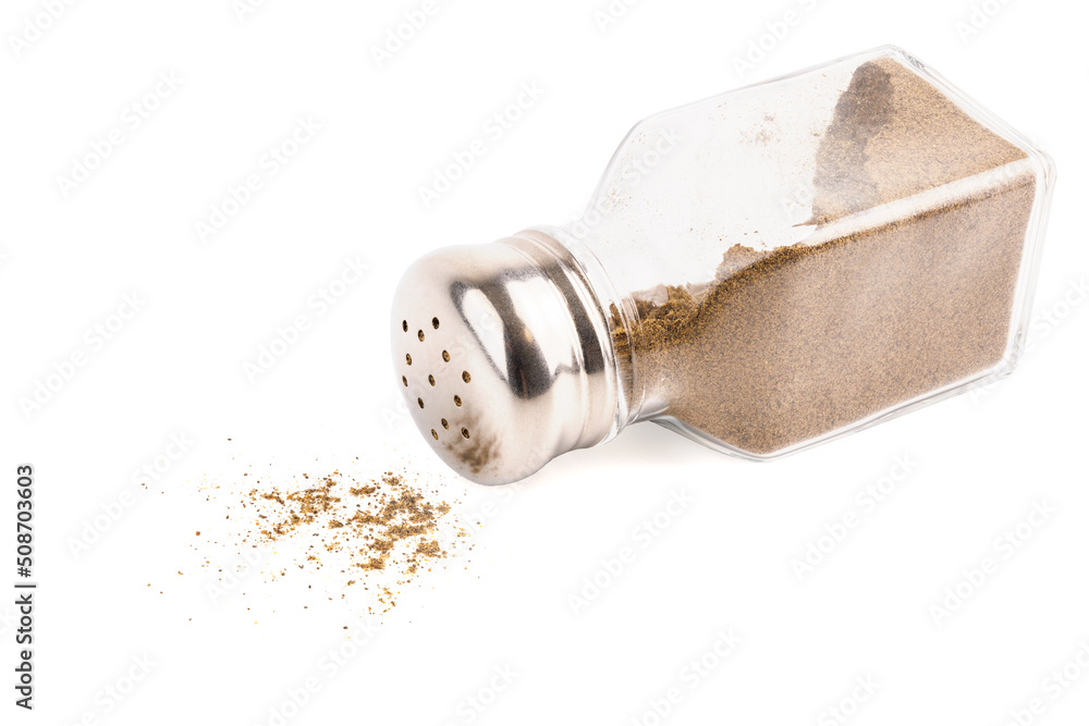 glass pepper pot with powdered black pepper inside dropped on its side ...