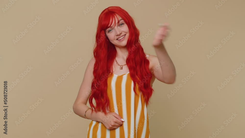 Come here, join us. Welcome. Redhead young woman showing inviting ...