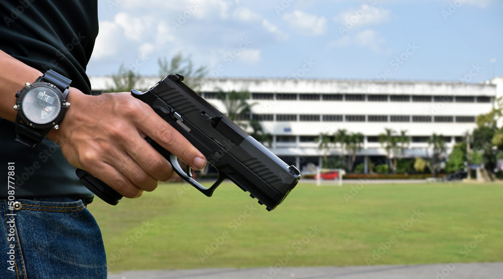 9mm pistol gun holding in right hands of shooter in front of the grass ...