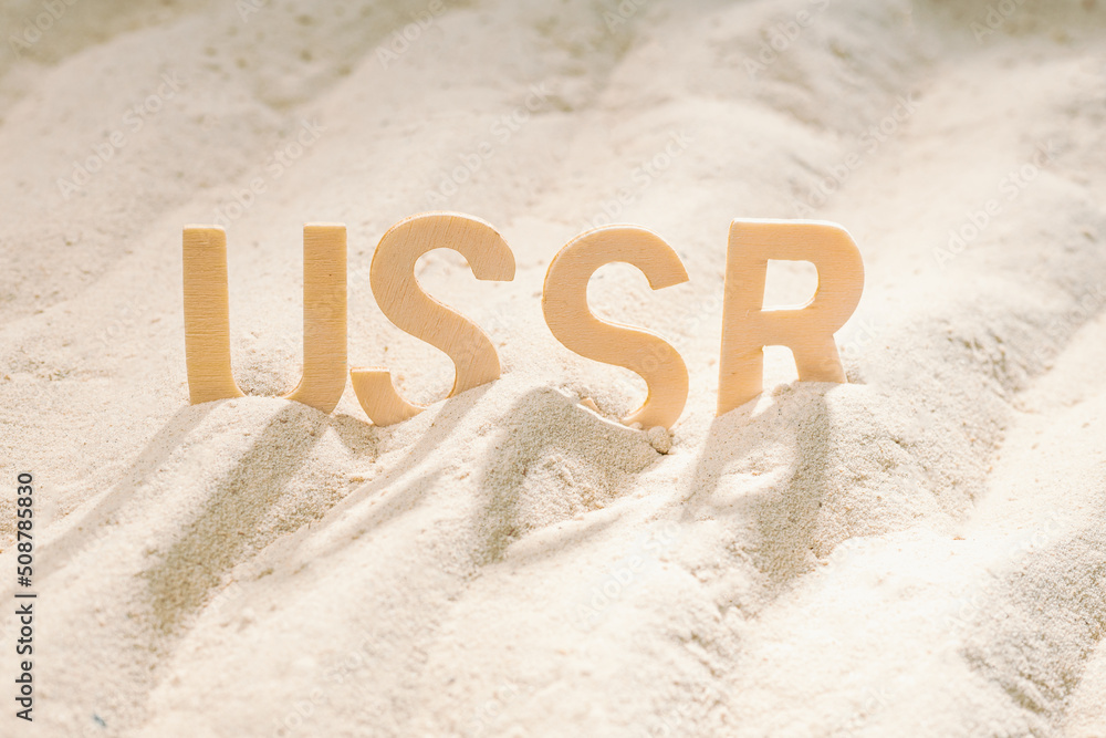 USSR word from wooden letters stuck in the rows of sand. old country in ...