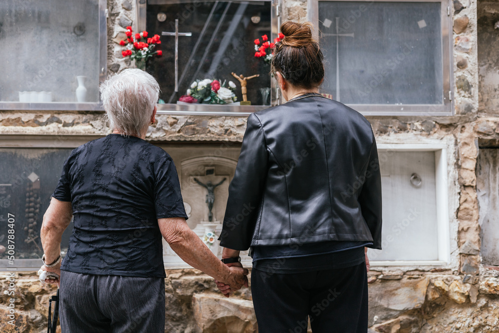 elderly mother and widow and orphaned daughter holding hands in front ...