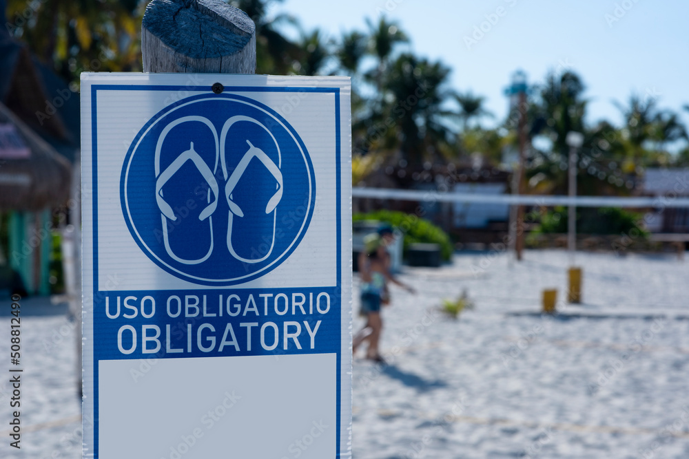 Sign in Spanish and English at the beach "obligatory". Mandatory to use ...