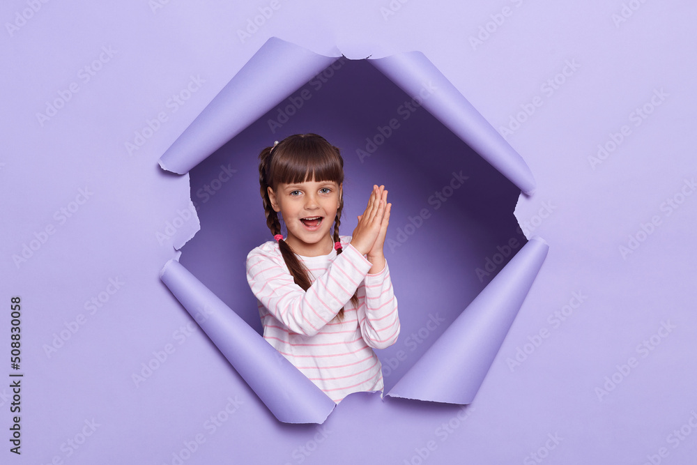 Indoor short of dark haired little girl with pigtails wearing striped ...