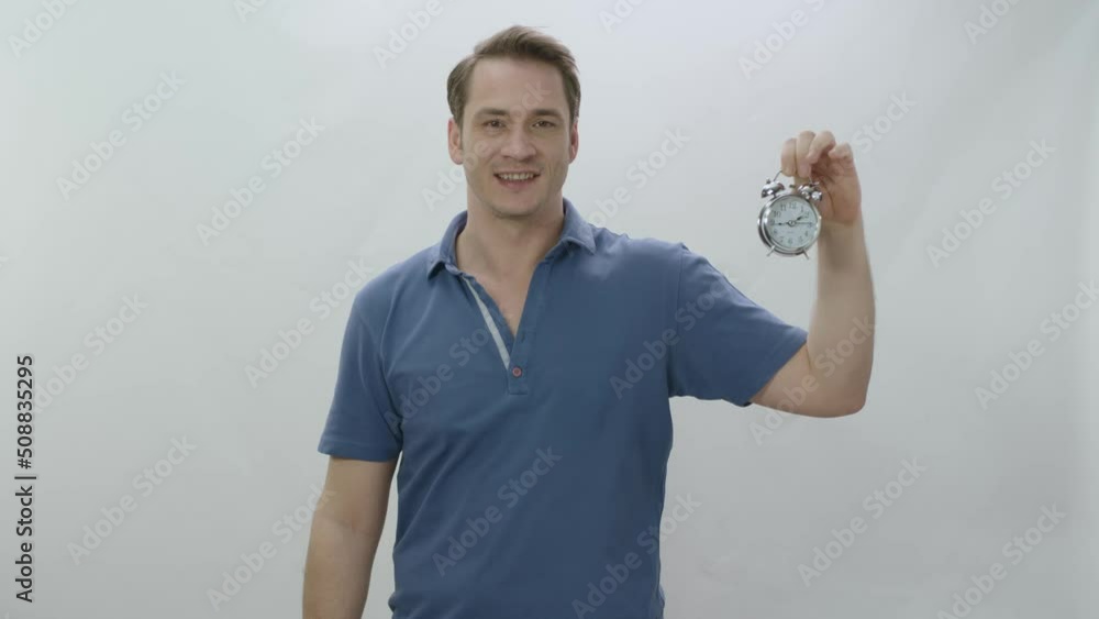 Character portrait of young man holding a small desk clock. The man ...