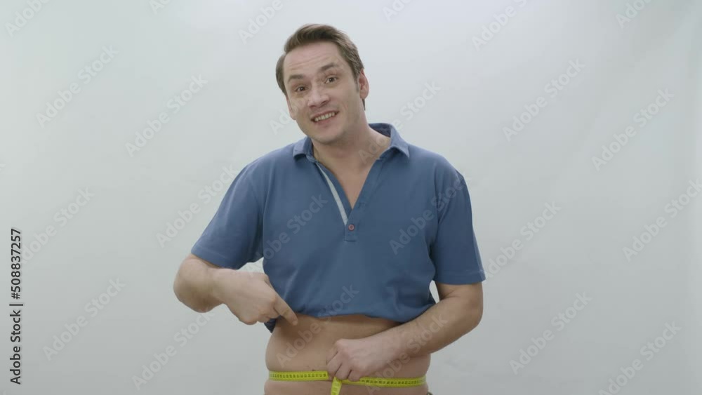 Man measuring hips and belly with tape measure.Young man measuring ...