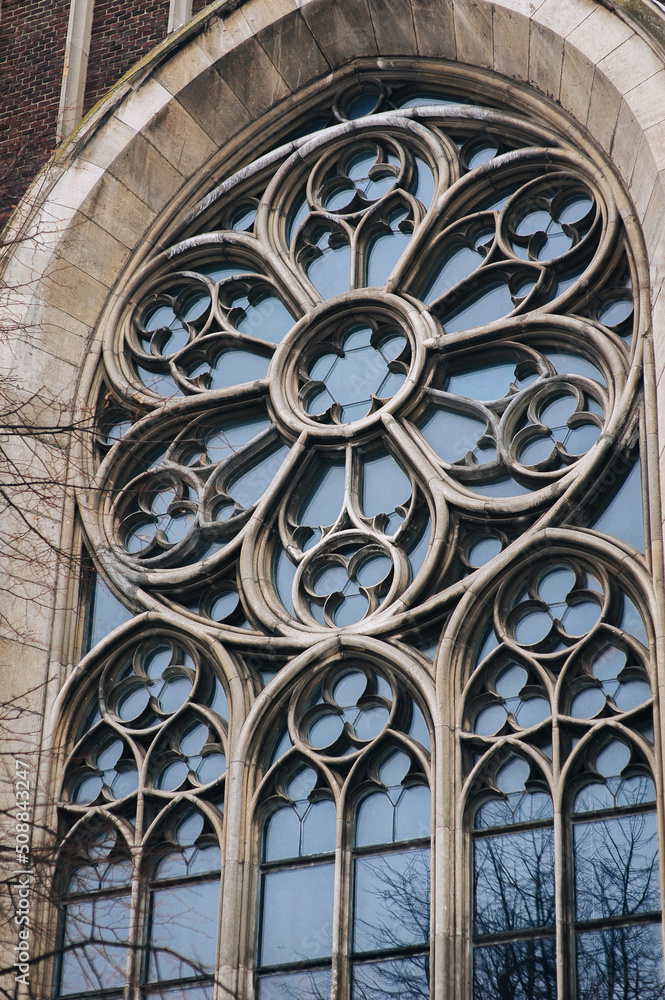 Round window with stained glass on facade of the building. Baroque and ...