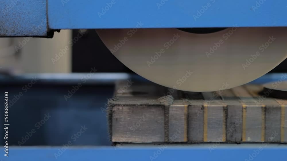 Side view: surface grinding wheel machine working with piece of metal ...