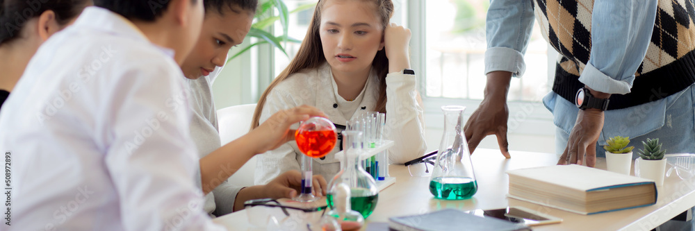 Young teacher teaching group student about science and test chemical ...