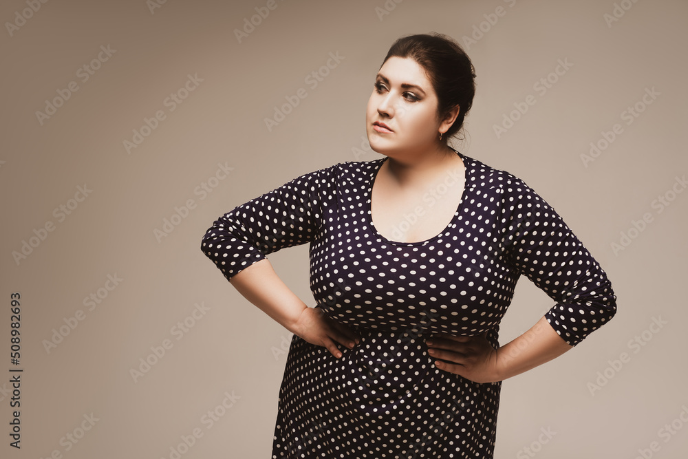 Plus size fashion model in polka dot dress, fat woman on studio ...