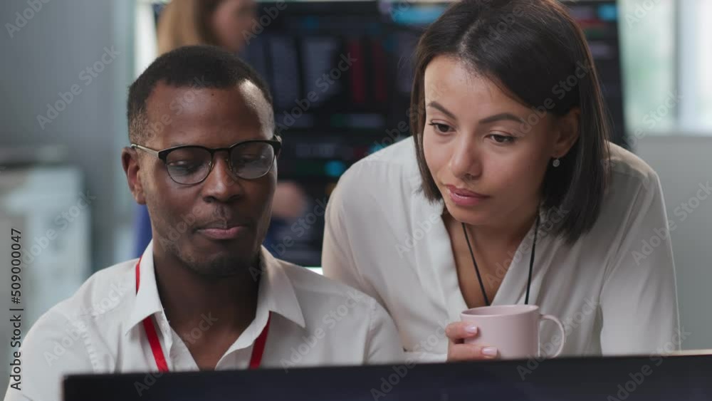 Close up of African-American colleagues look at computer screen and ...
