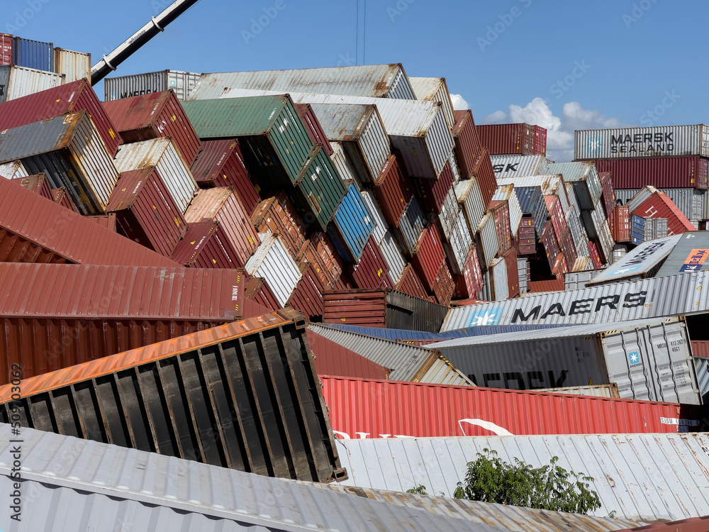 Chaos and damage to toppled shipping containers caused by severe storms and floods in a storage ...