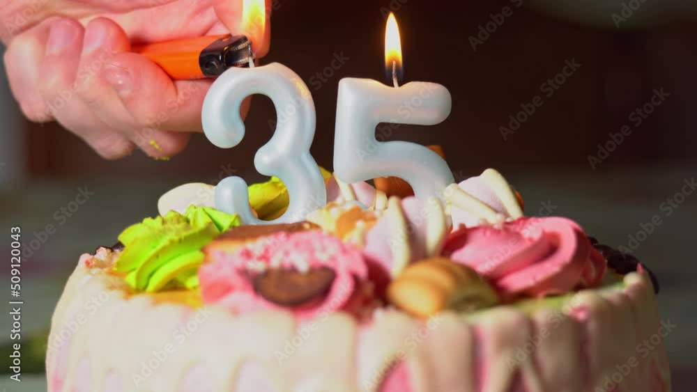 Lighting candles on a birthday cake. 35th birthday. Birth cake with a ...