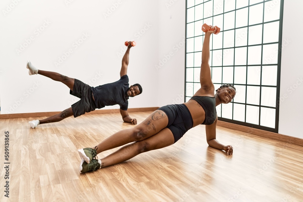 Young african american sporty couple training power exercise using ...