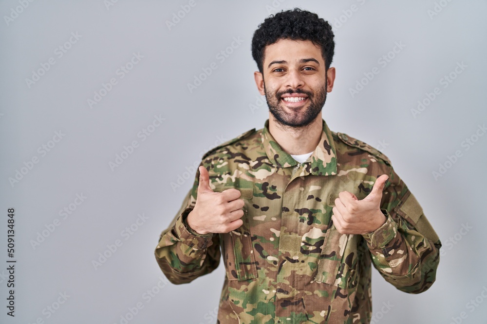 Arab man wearing camouflage army uniform success sign doing positive ...