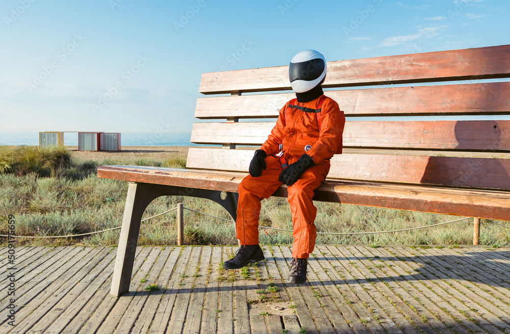 Spaceman sitting on giant bench Stock Photo | Adobe Stock