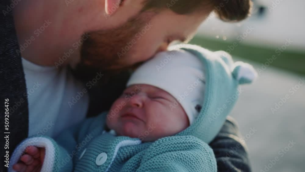 Dad hugs kisses his little new born daughter. Baby crying in park in ...