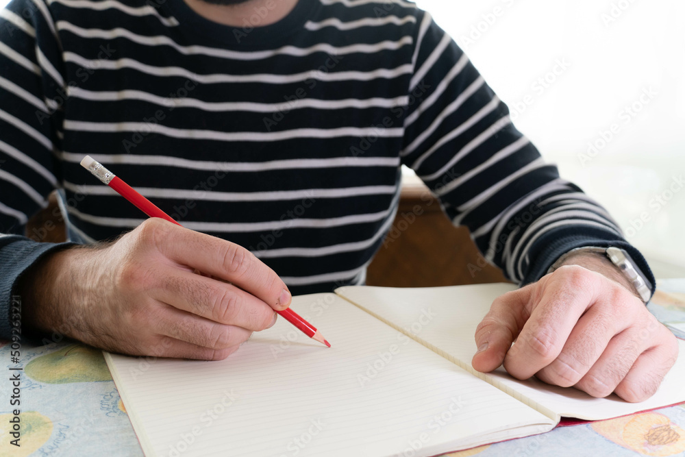 hombre escribiendo en un cuaderno rayado con una pluma y un lapiz Stock ...