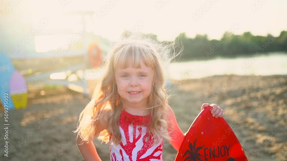 Pretty little girl in red bikini posing with small surfboard like a ...