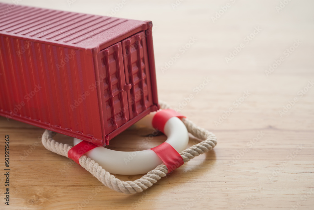 Red container on lifebuoy wooden table background with copy space ...