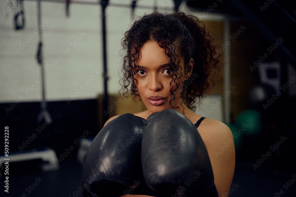 African American female boxer training at the gym with boxing gloves on ...