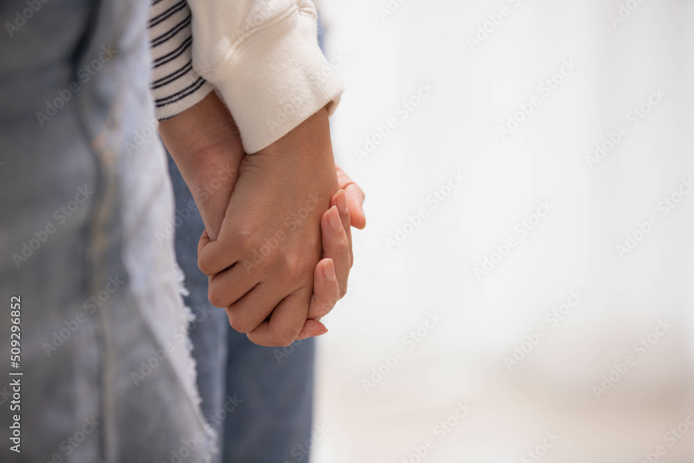 Close up hand of two female holding hands two girls sitting on bed hand ...