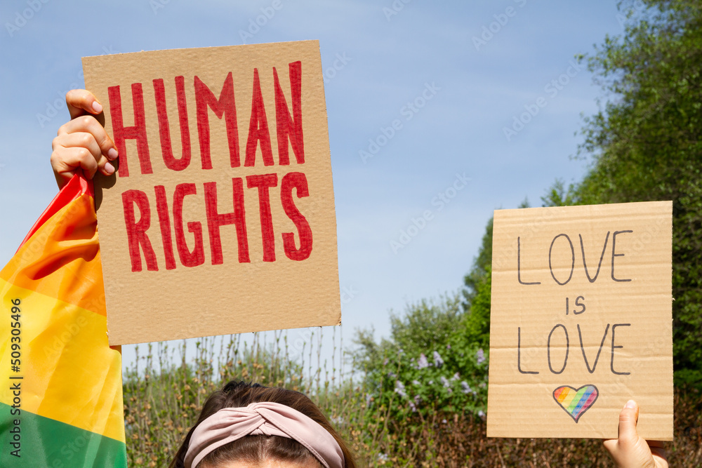 Protesters holding placard signs Human Rights and Love is Love with ...