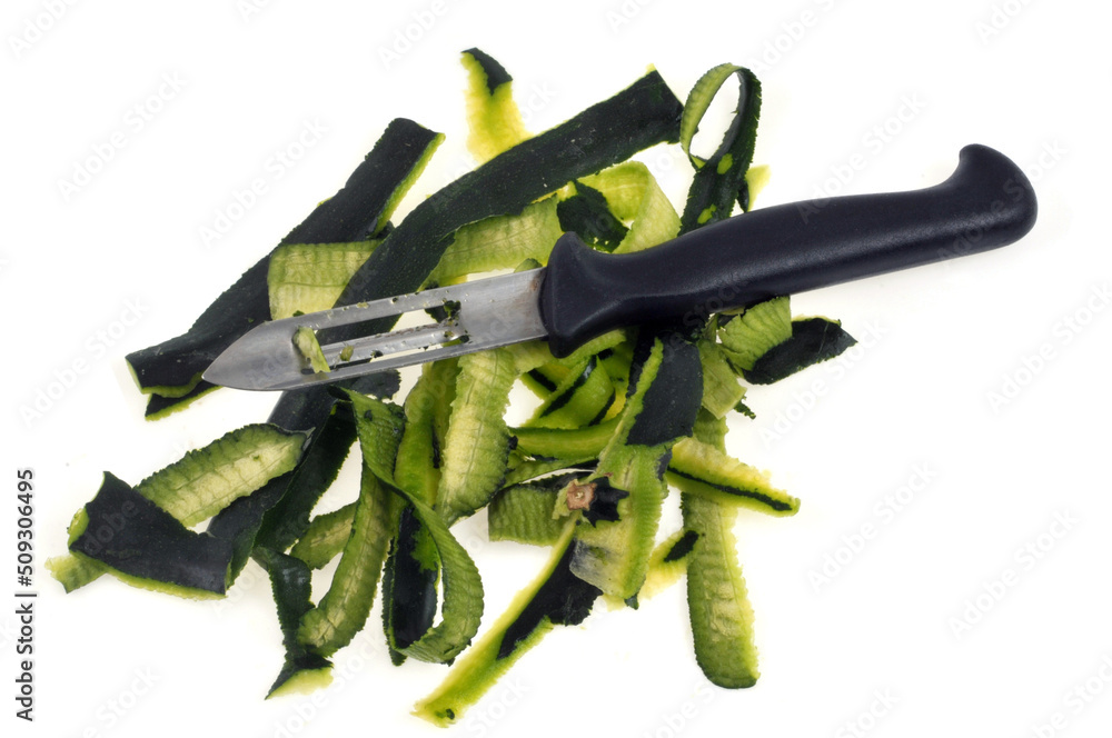 Foto de Un épluche légume posé sur des épluchures de courgette sur fond ...