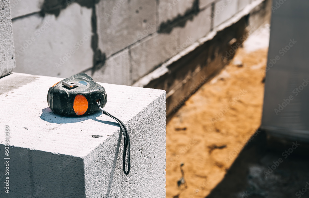 The tape measure lies on a gas silicate block close-up. Construction ...