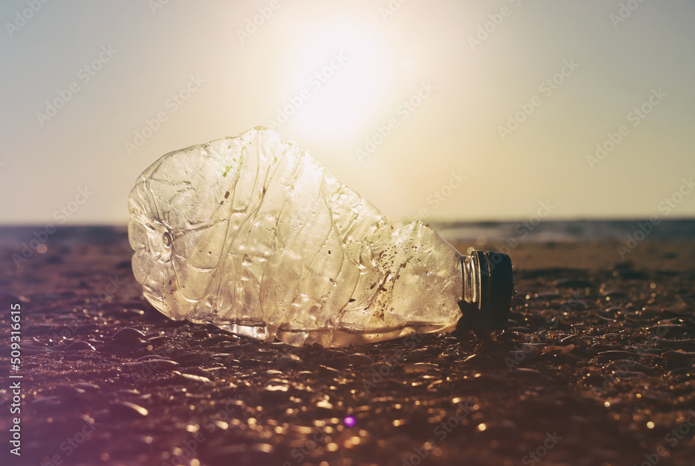Plastic bottle thrown on the beach . Concept of environmental pollution ...