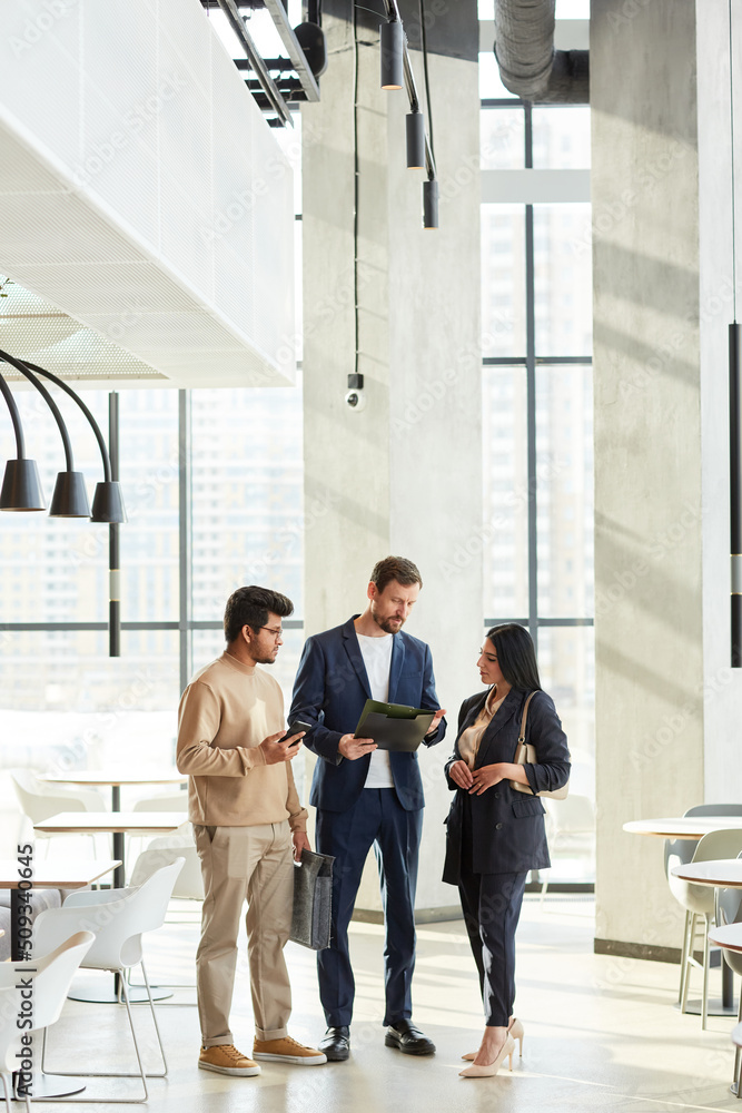Minimal full length portrait of three business people talking in ...