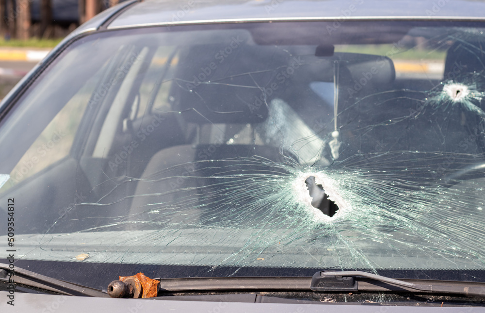 Holes on the windshield of the car, it was shot from a firearm. Bullet ...