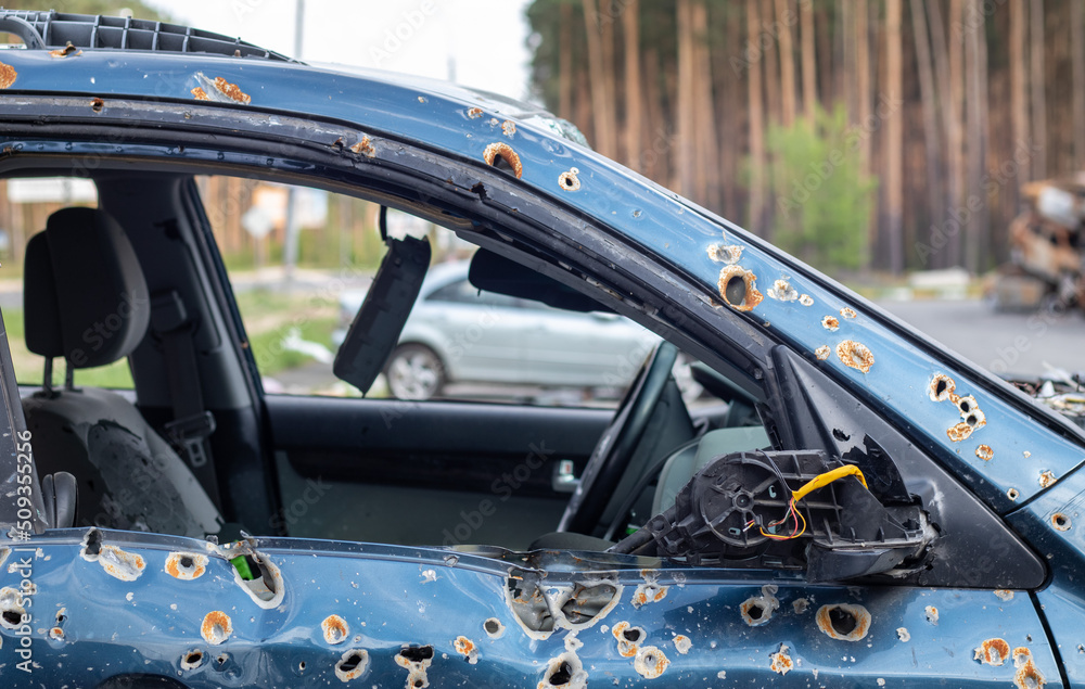 Car riddled with bullets. War of Russia against Ukraine. A car of ...