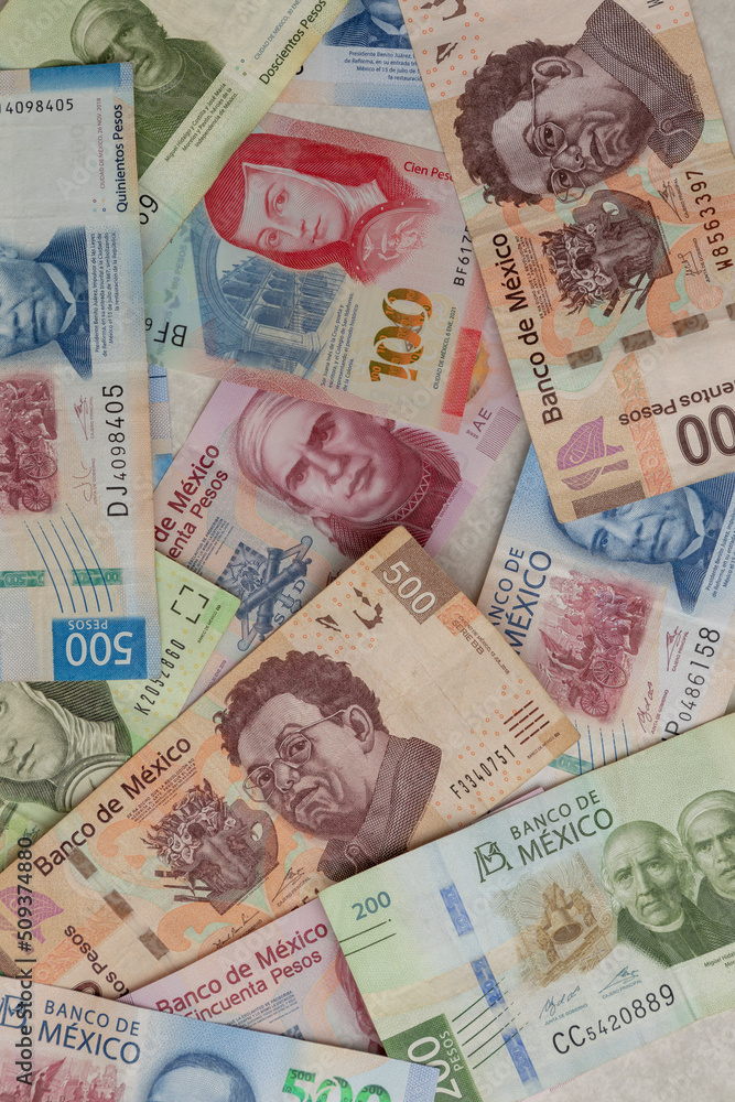 Vertical image of Mexican pesos bills of various denominations on a ...