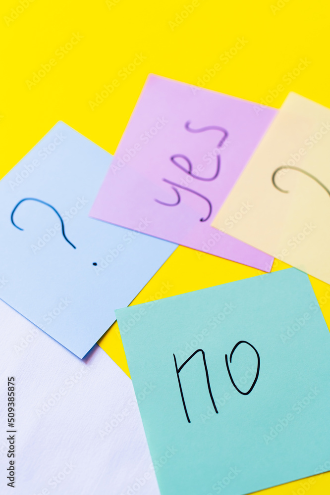 top view of paper notes with question mark near yes and no lettering on ...