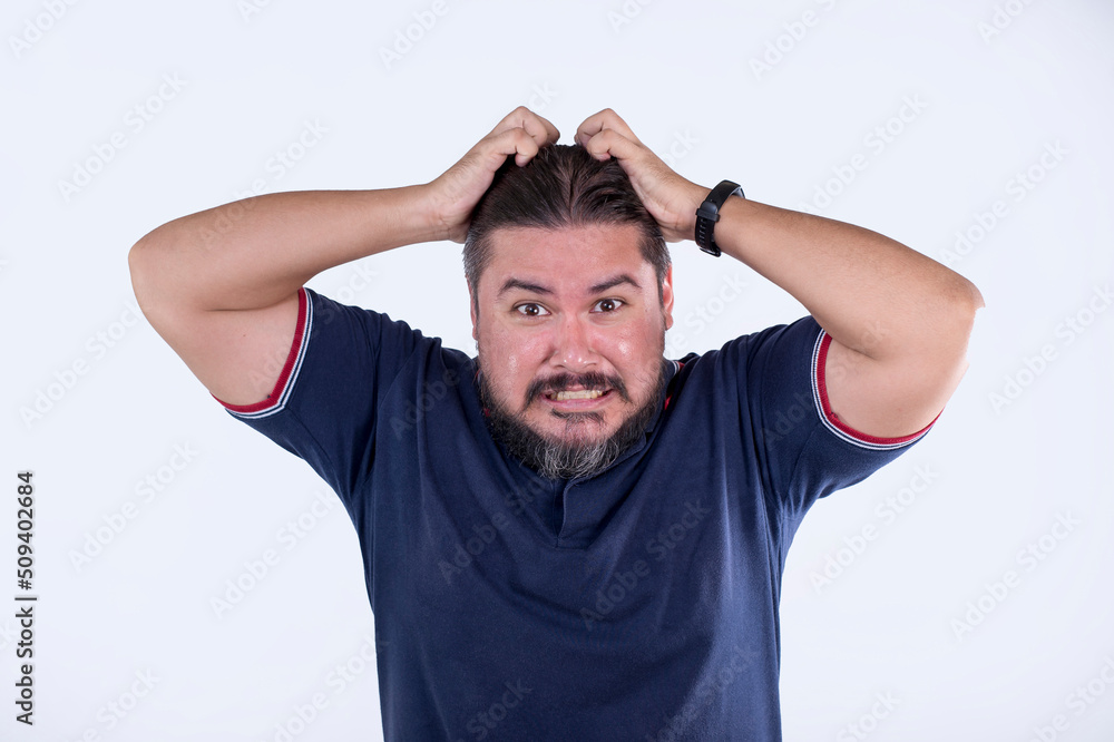 A bearded man stabs his fingers into his scalp from frustration ...