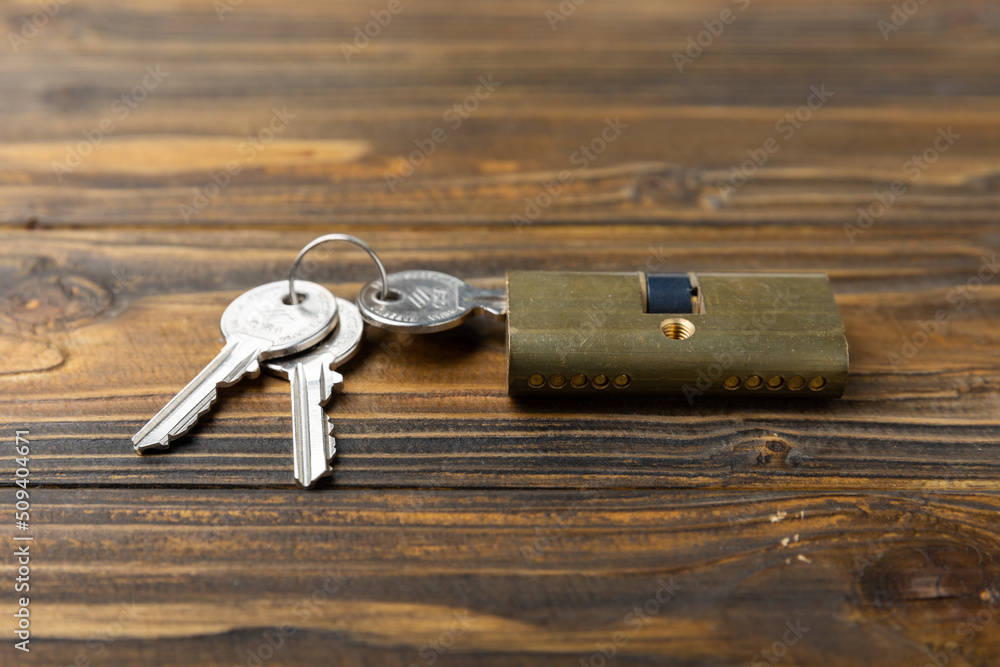 New door lock on brown texture background. Patent and keys to the front ...