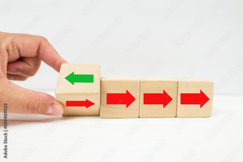 Hand flip over wooden cube block with red arrow facing the opposite ...